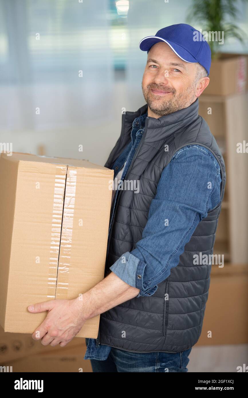 smiling friendly delivery man carrying parce Stock Photo - Alamy