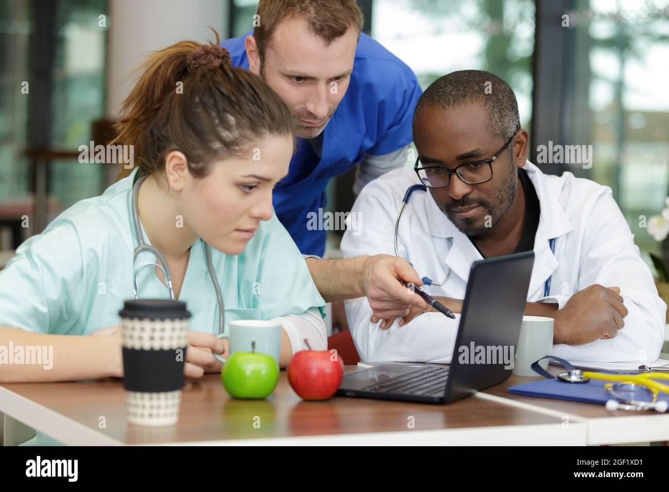 team of doctors using desktop pc together during lunch time Stock Photo ...