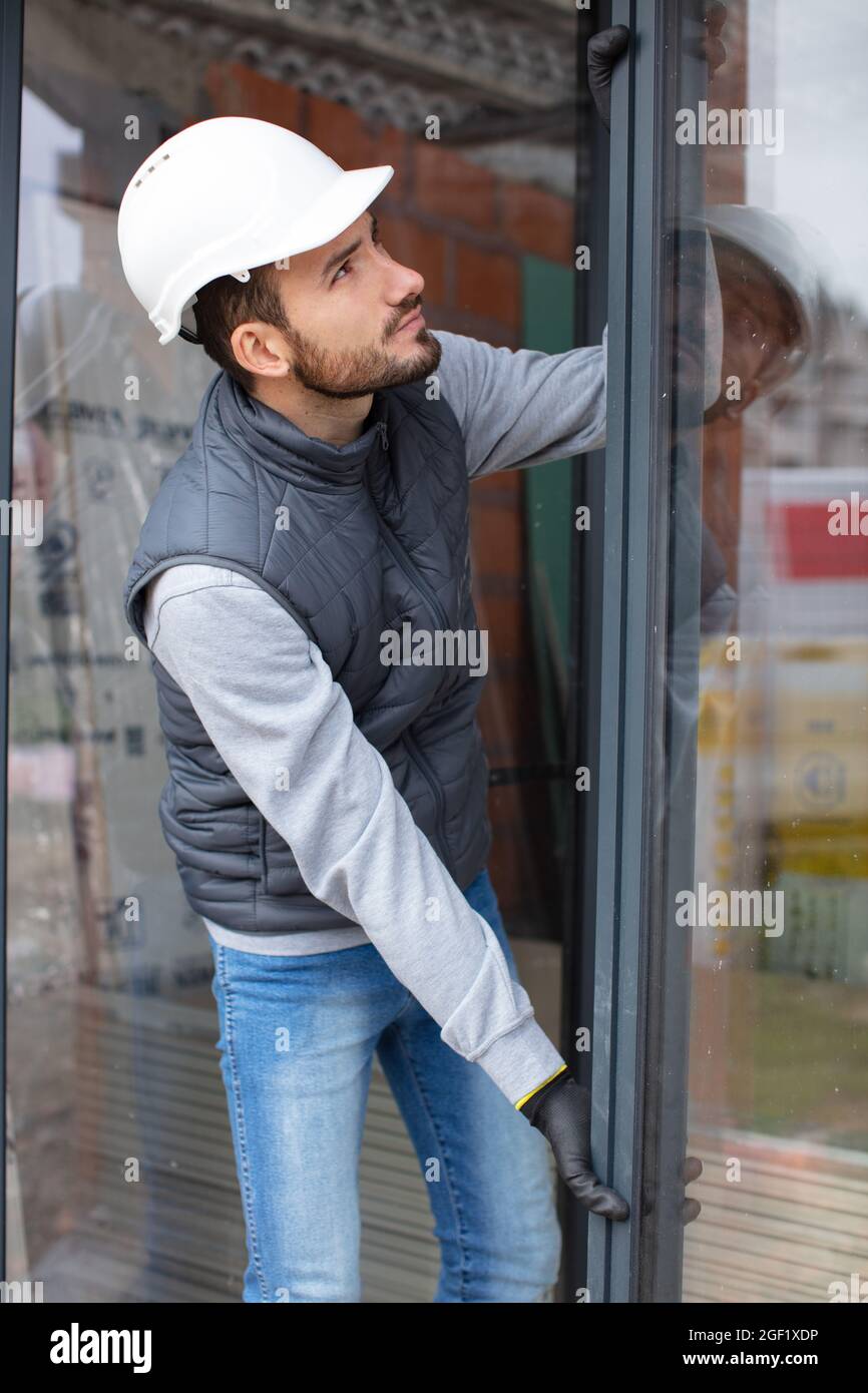 handsome young man installing bay window in a new house Stock Photo - Alamy