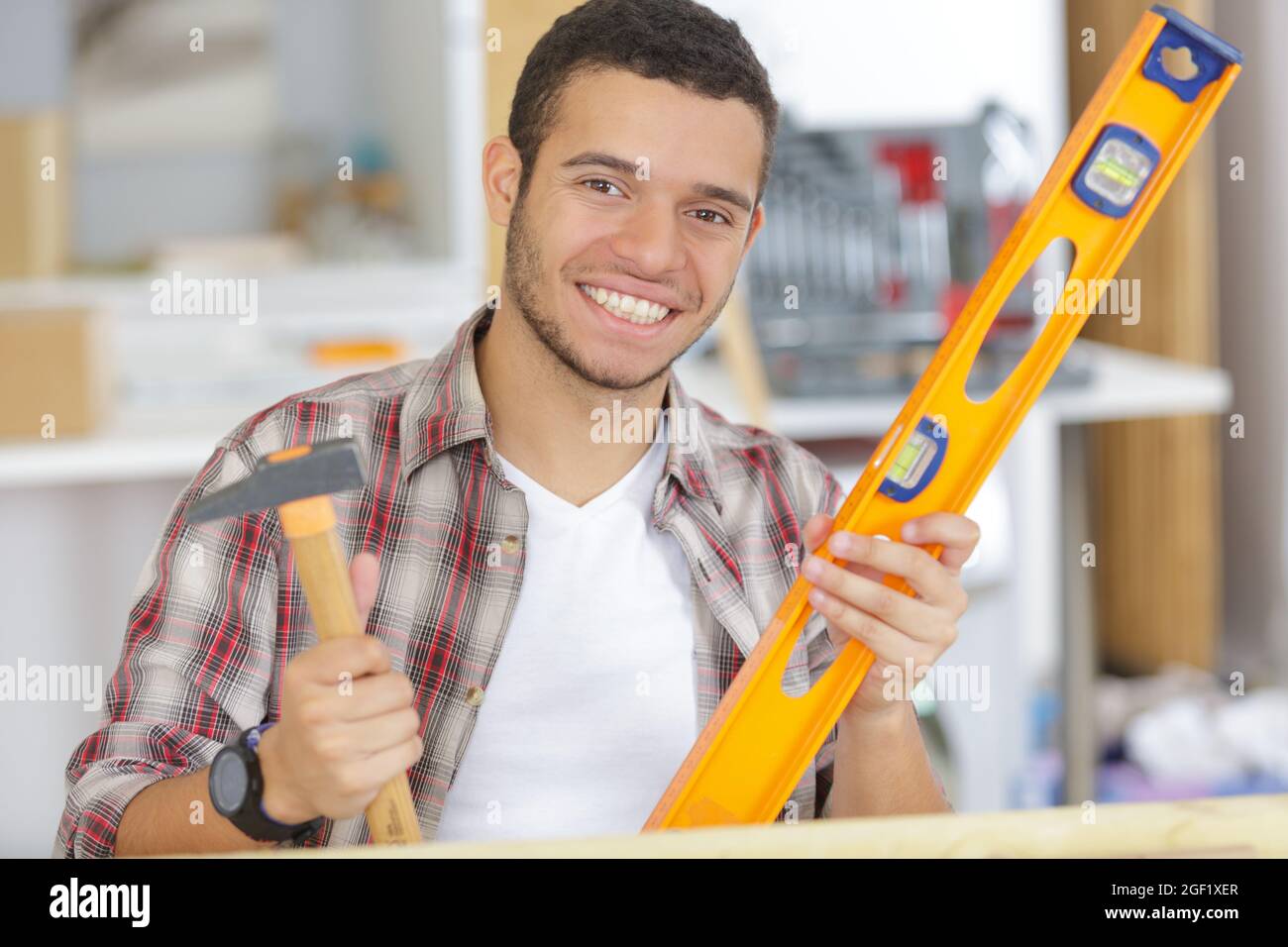 construction worker with spirit level and hammer Stock Photo - Alamy