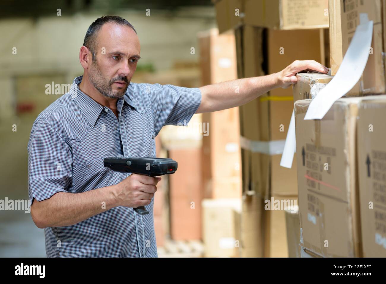 mature warehouse worker with handheld scanner Stock Photo - Alamy