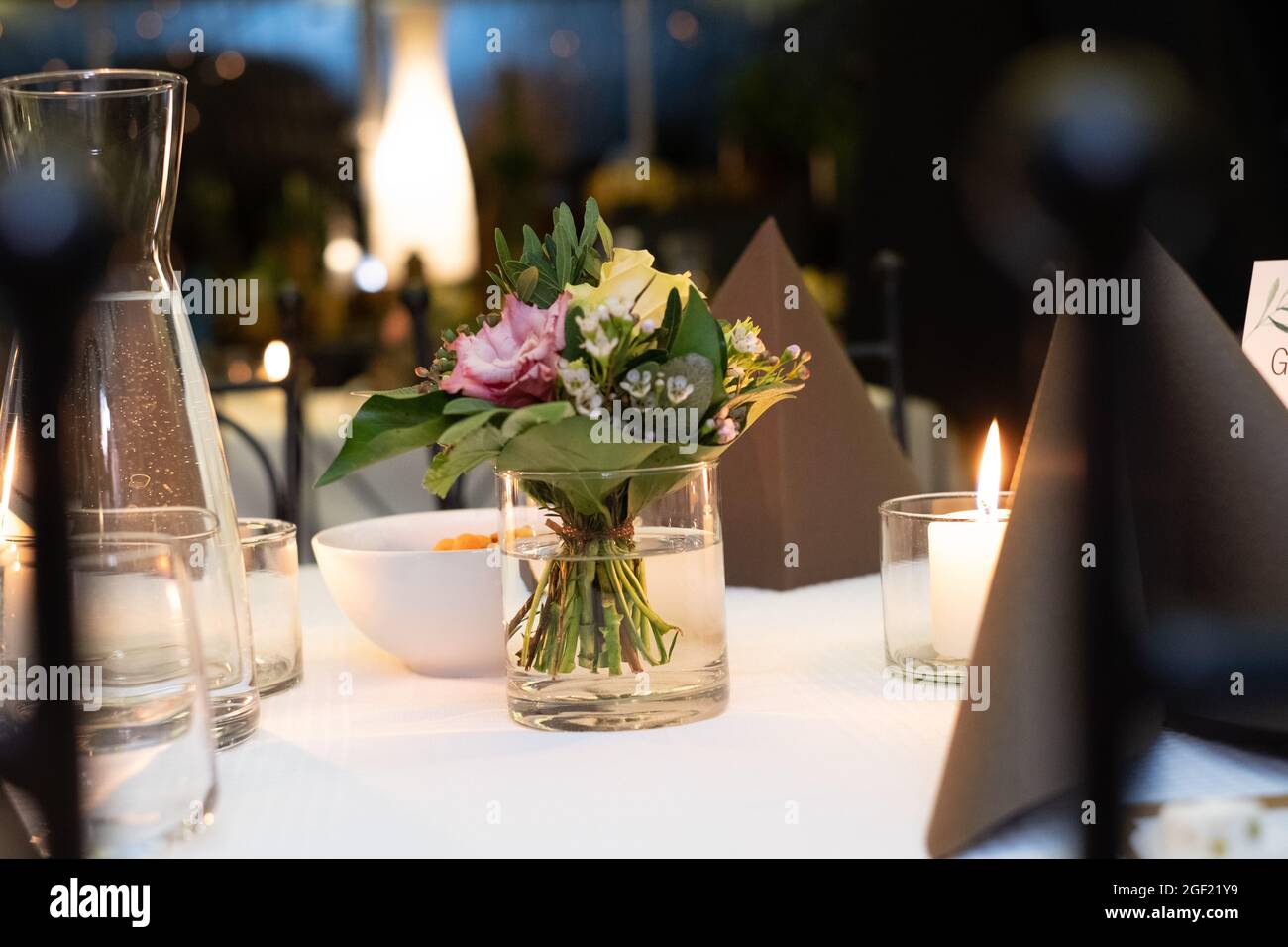 Selective focus of flowers in glass on an elegant table set up in a wedding reception Stock ...