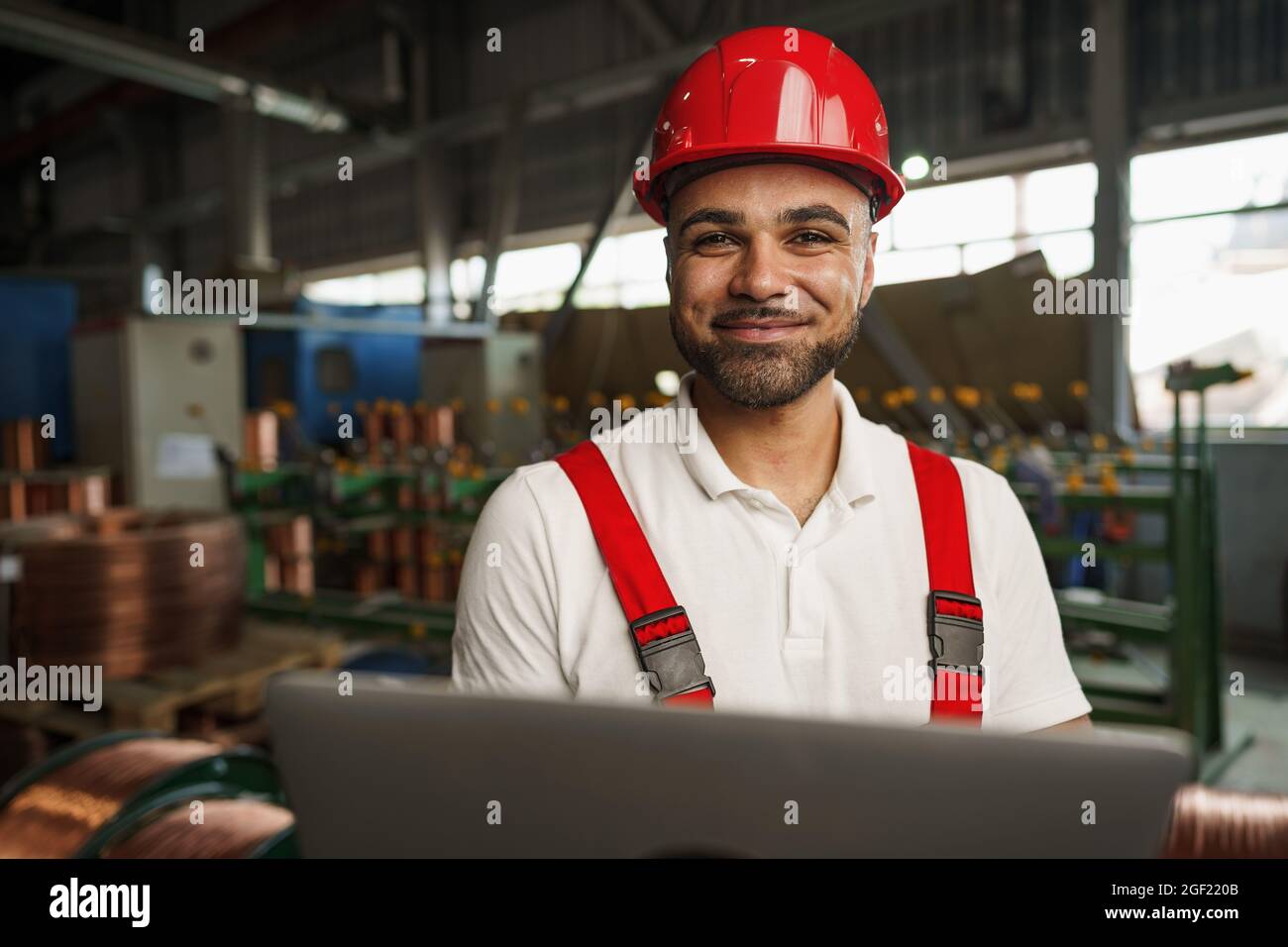 Industrial worker with laptop working in a cable production plant Stock ...