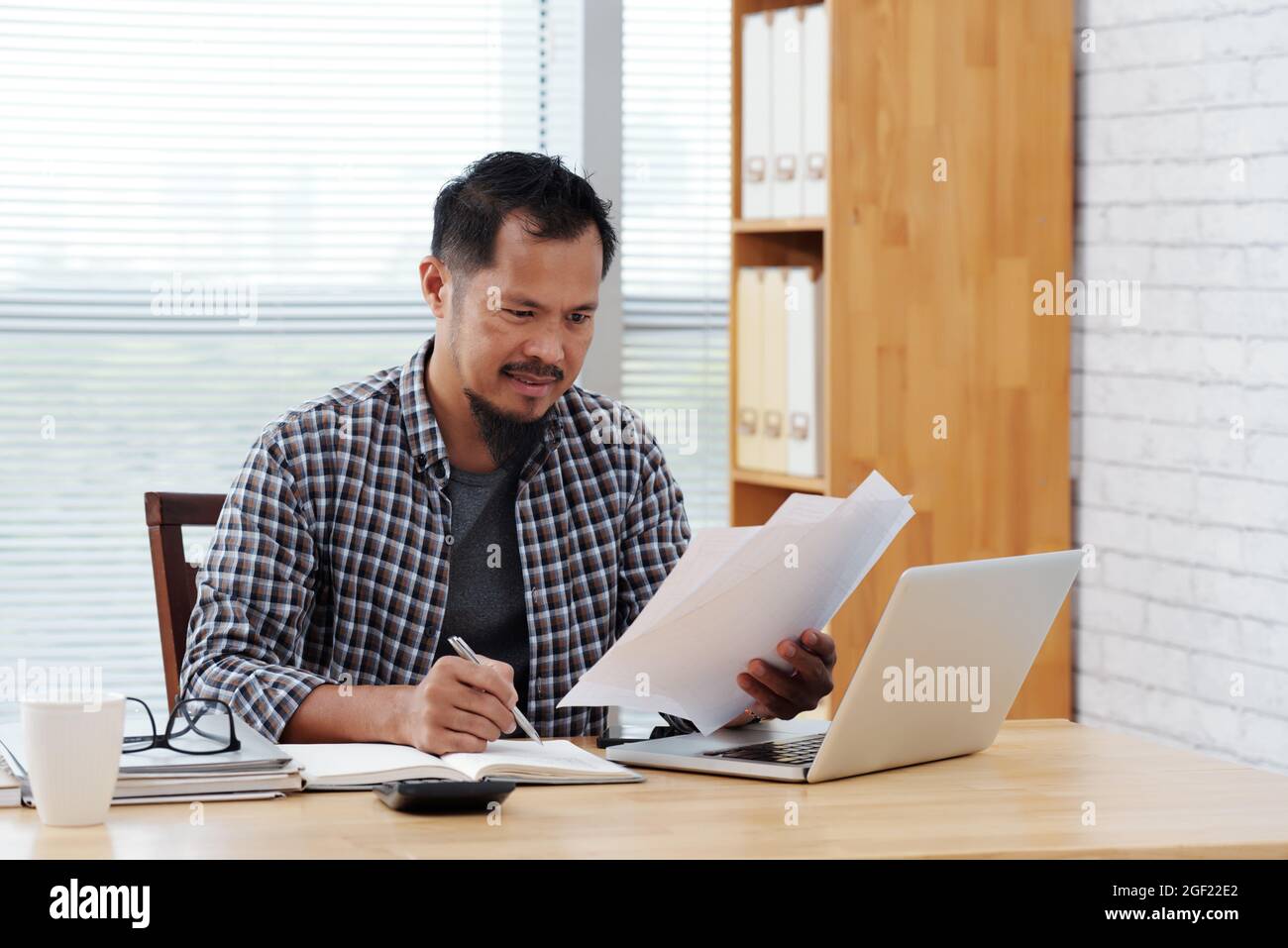 Entrepreneur reading confusing terms of contract and writing down ideas ...