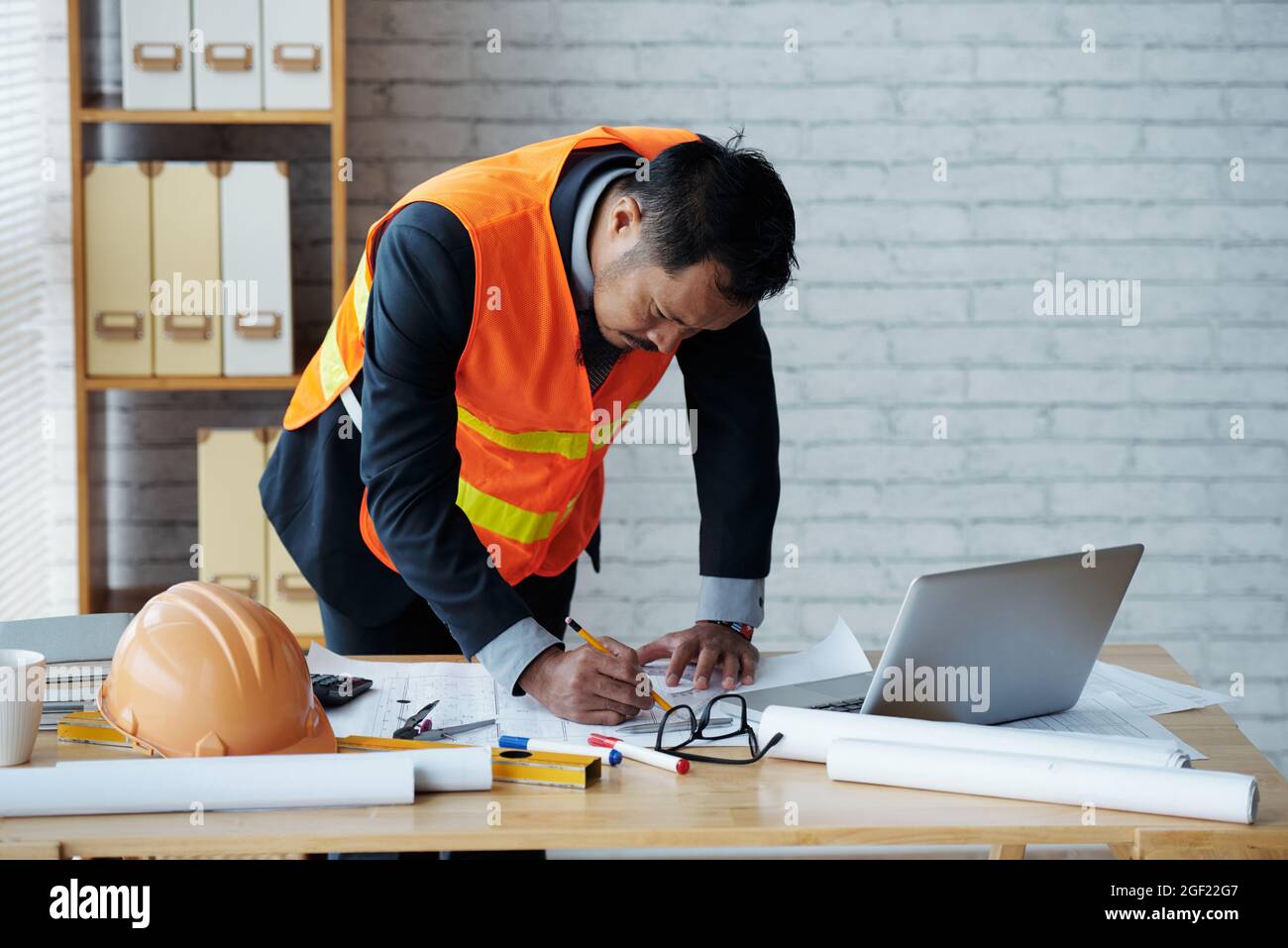Civil engineer in range vest making corrections in construction plan on ...