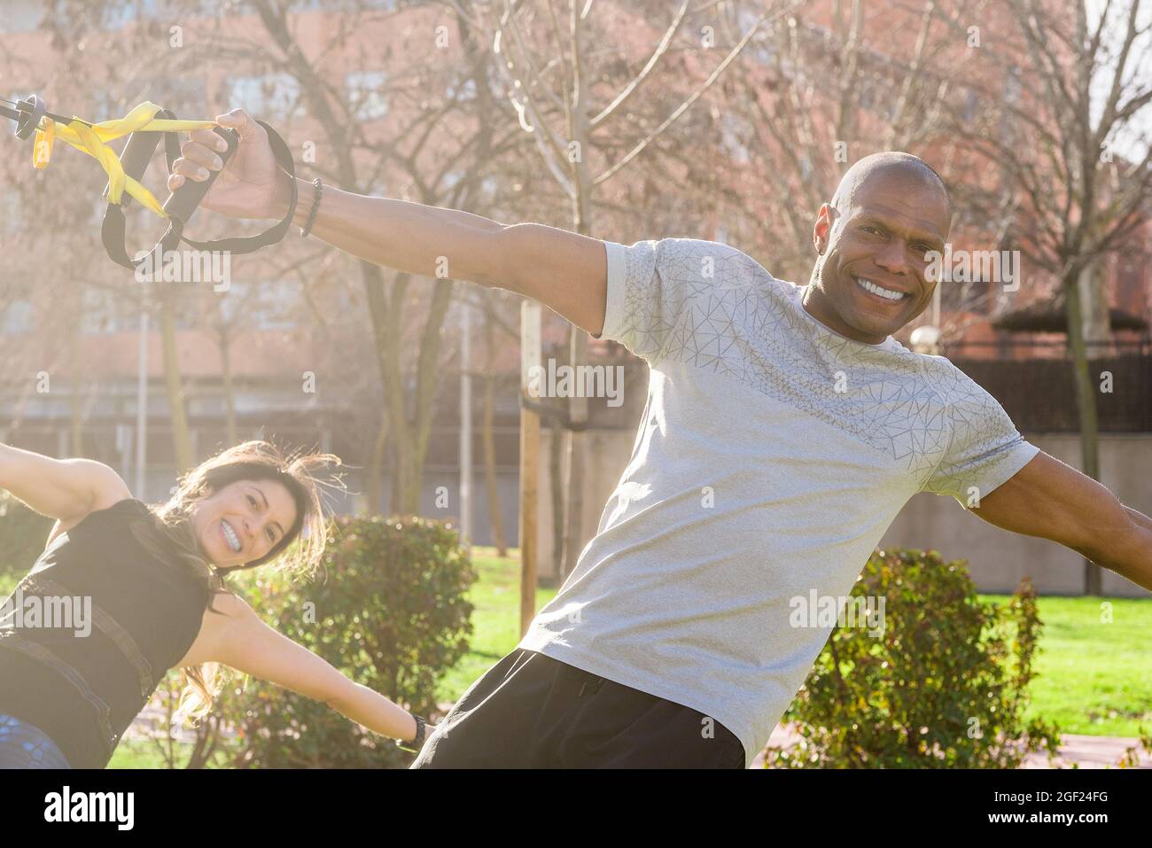 Male and female athletes doing lateral arm exercises with fitness ...