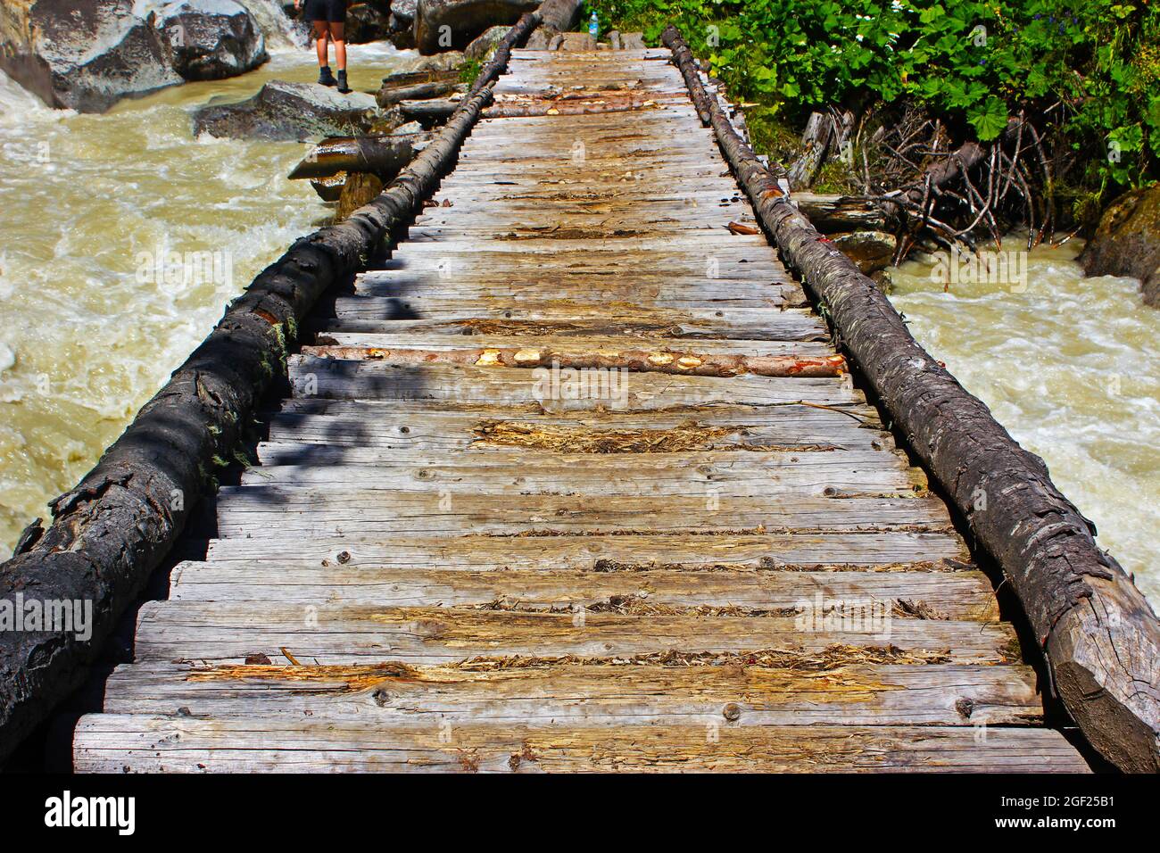 Wooden bridge over the raging river Stock Photo - Alamy