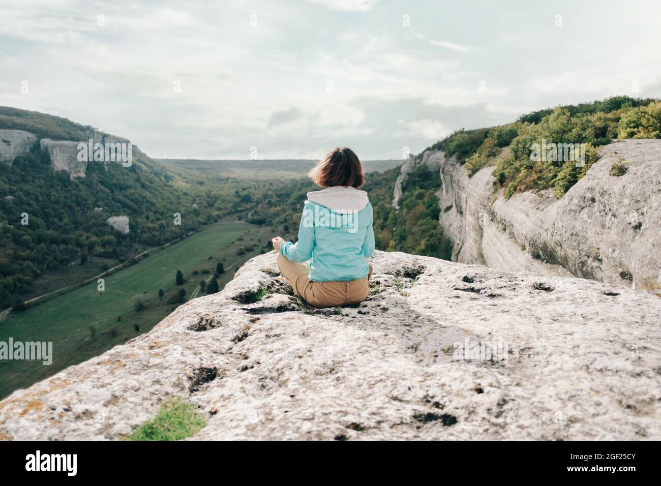 Girl sitting on edge cliff hi-res stock photography and images - Alamy