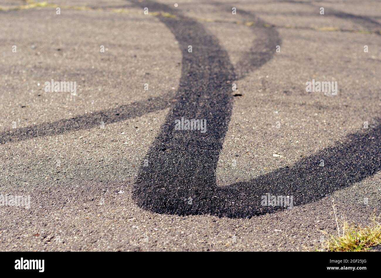 Black traces of car tires on the asphalt. Curved traces of burnt rubber ...