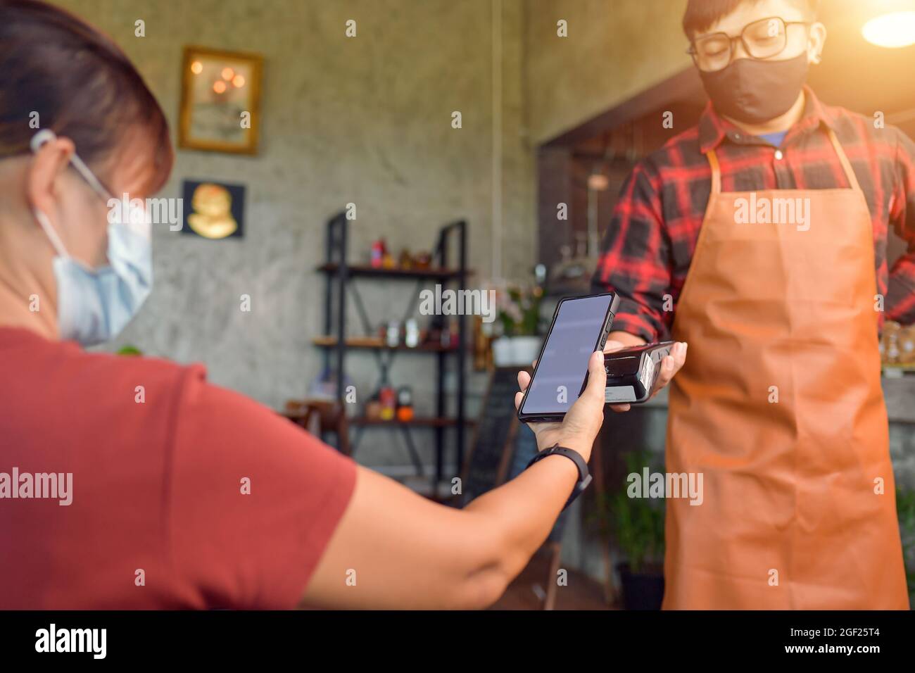 Contactless payment method. Closeup of a customer using her smartphone ...