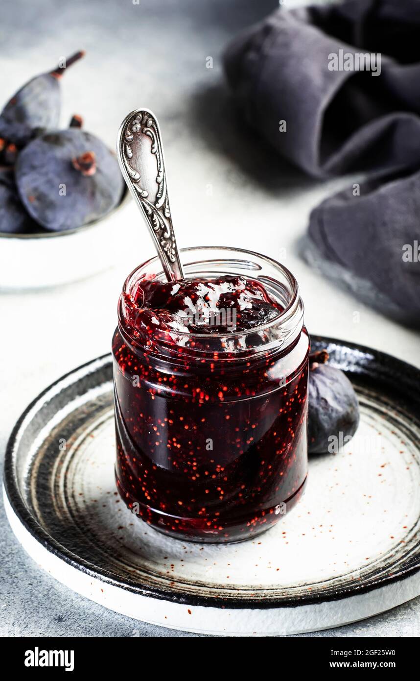 Fig confiture in glass jar. Fresh fruits on gray kitchen table ...