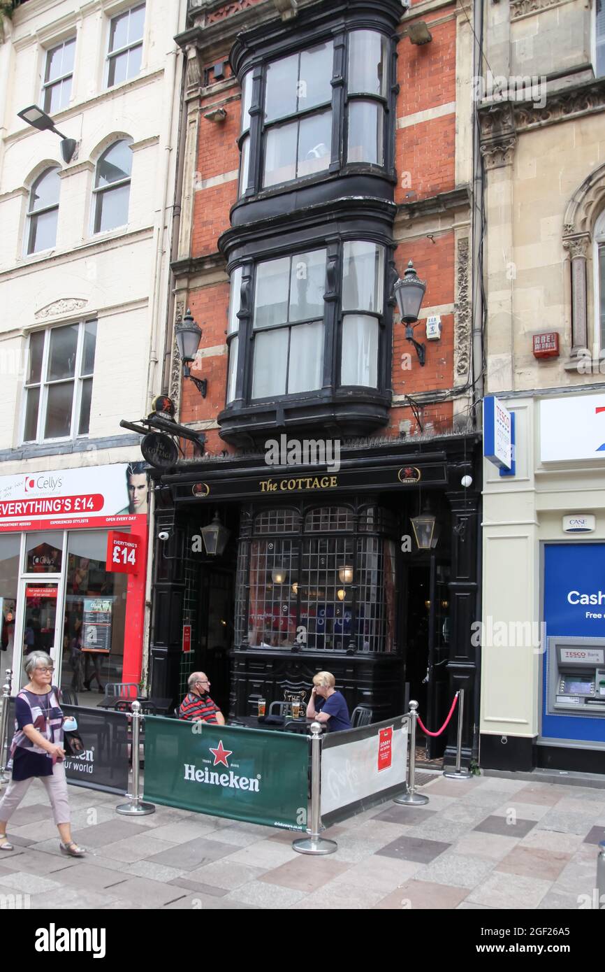 Two people drinking beer outside The Cottage public house, St. Mary ...