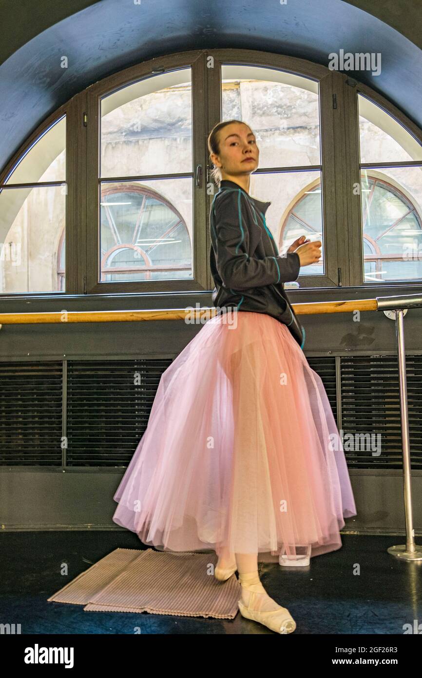 Young ballet dancer dressed in a tutu practices her dance in a ...