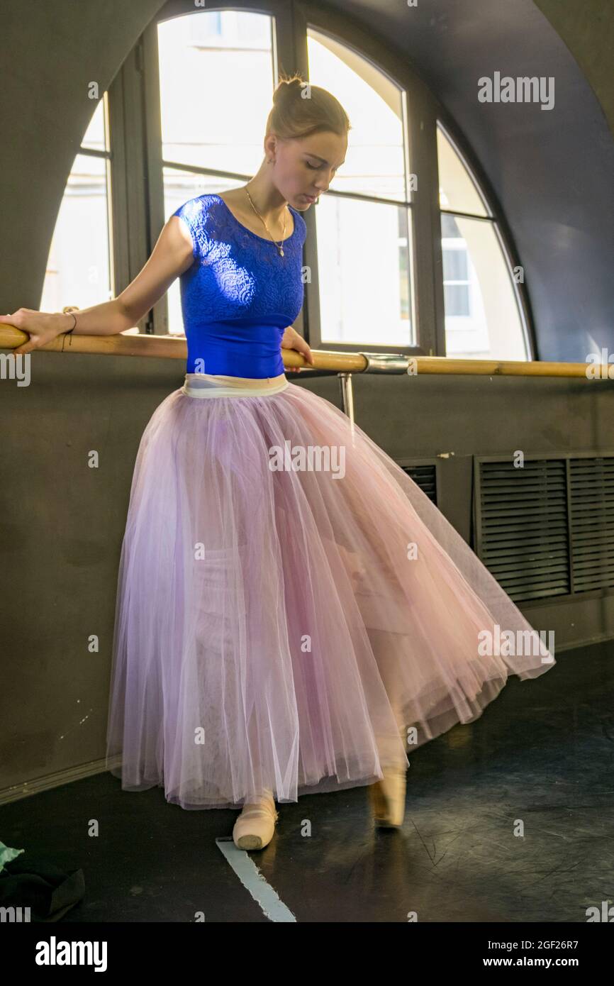 Young ballet dancer dressed in a tutu practices her dance in a ...