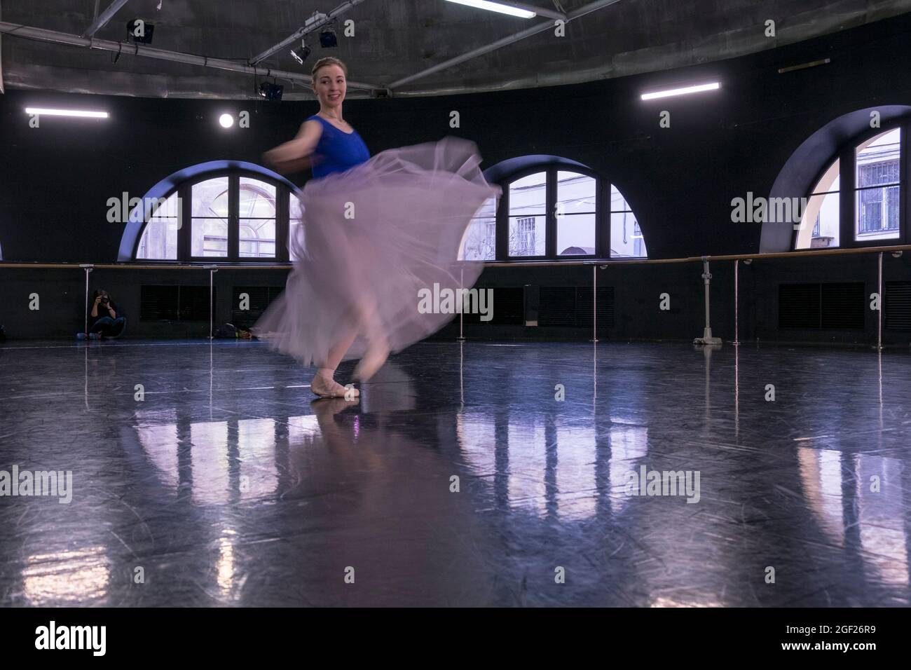 Young ballet dancer dressed in a tutu practices her dance in a ...
