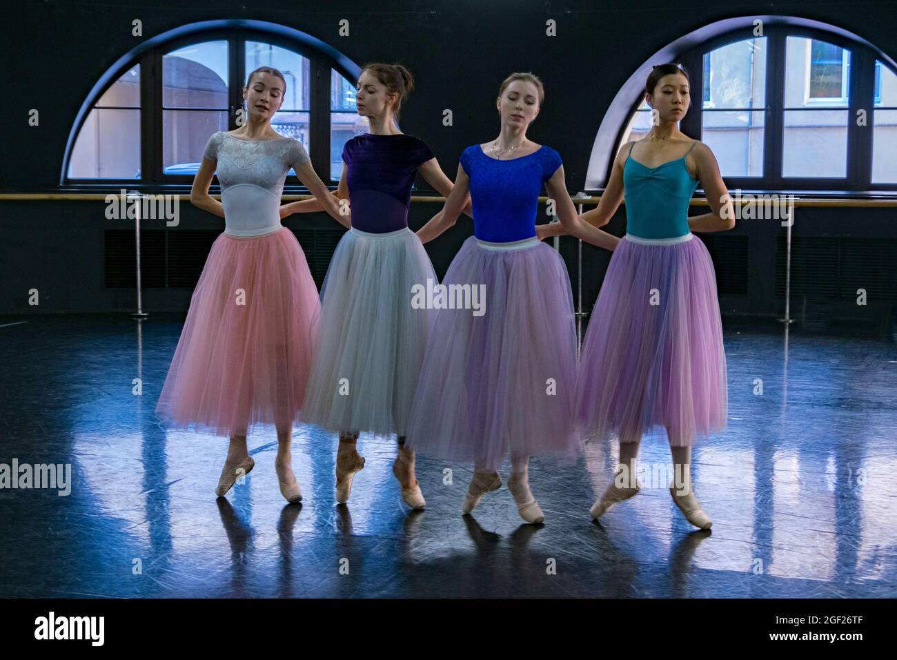 Four young female ballet dancers dressed in colorful tutus rehearse for ...