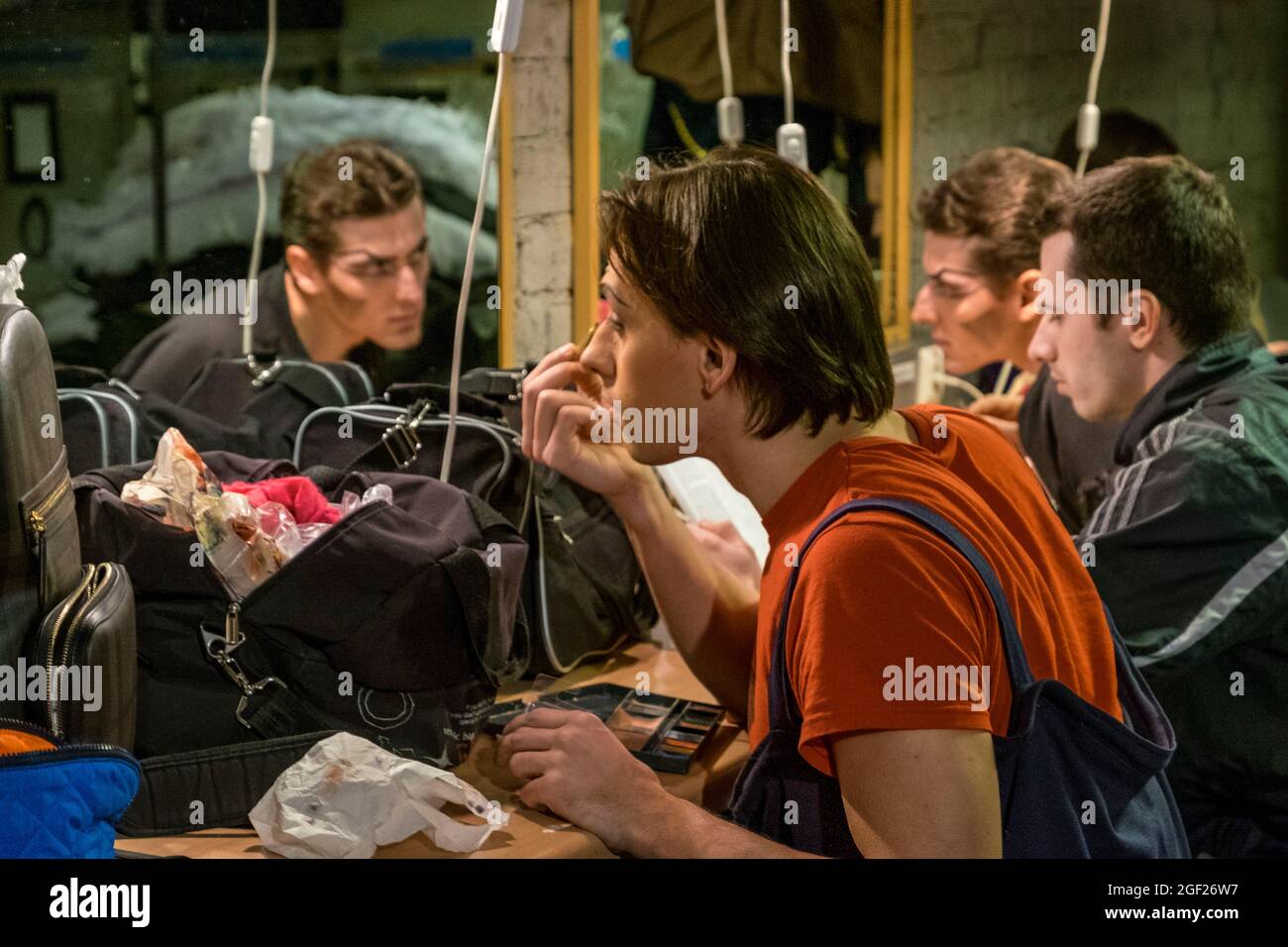 Male ballet dancers apply makeup for their roles in a production of ...