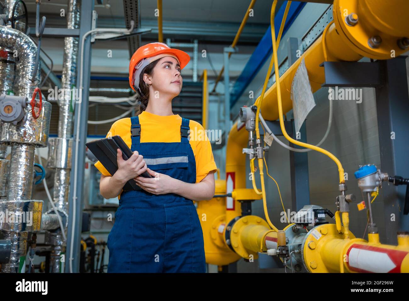 Production inspection. A young engineer in a uniform and a protective ...