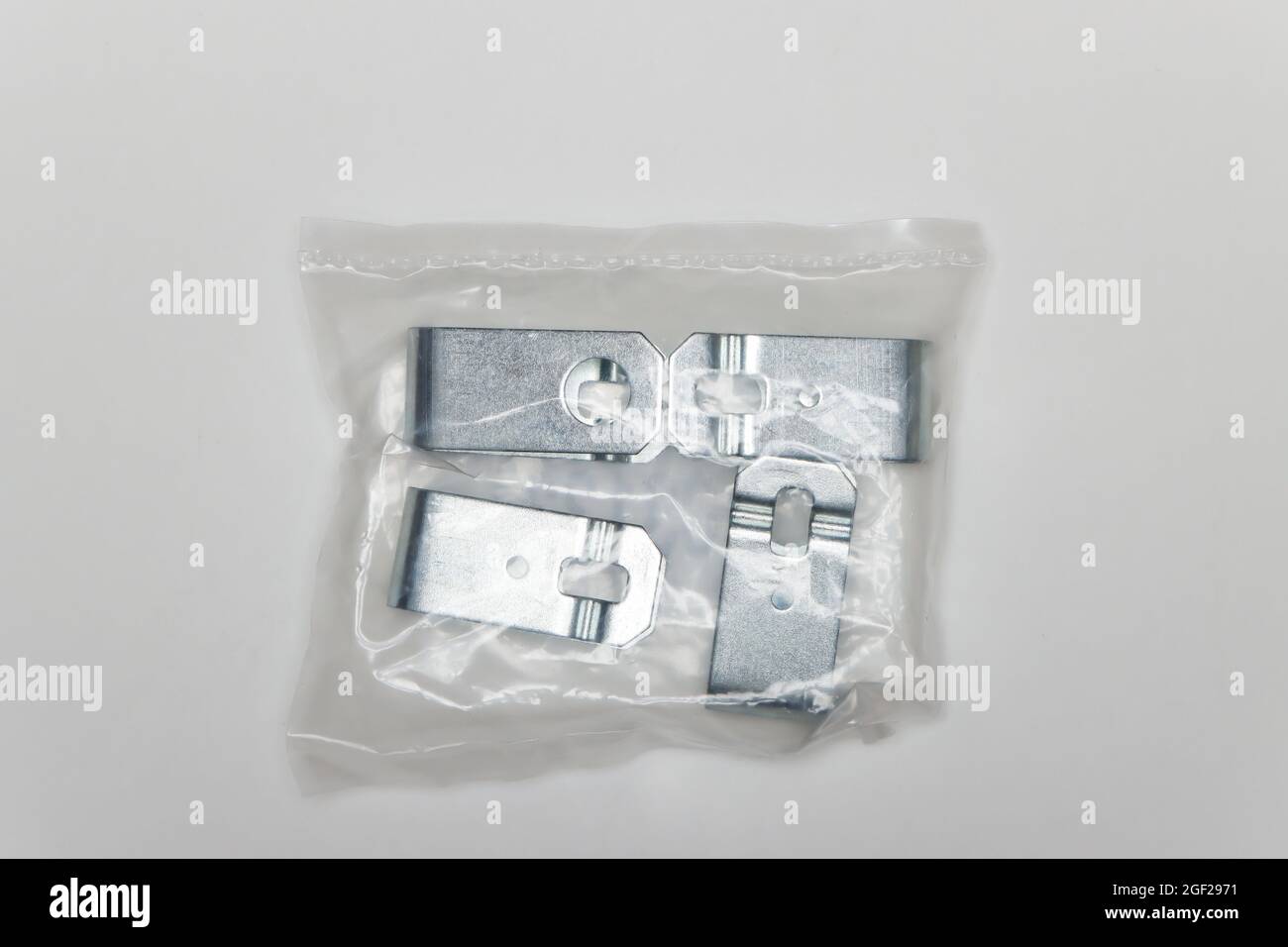 A set of metal plates in the package, parts for car repair. A set of ...