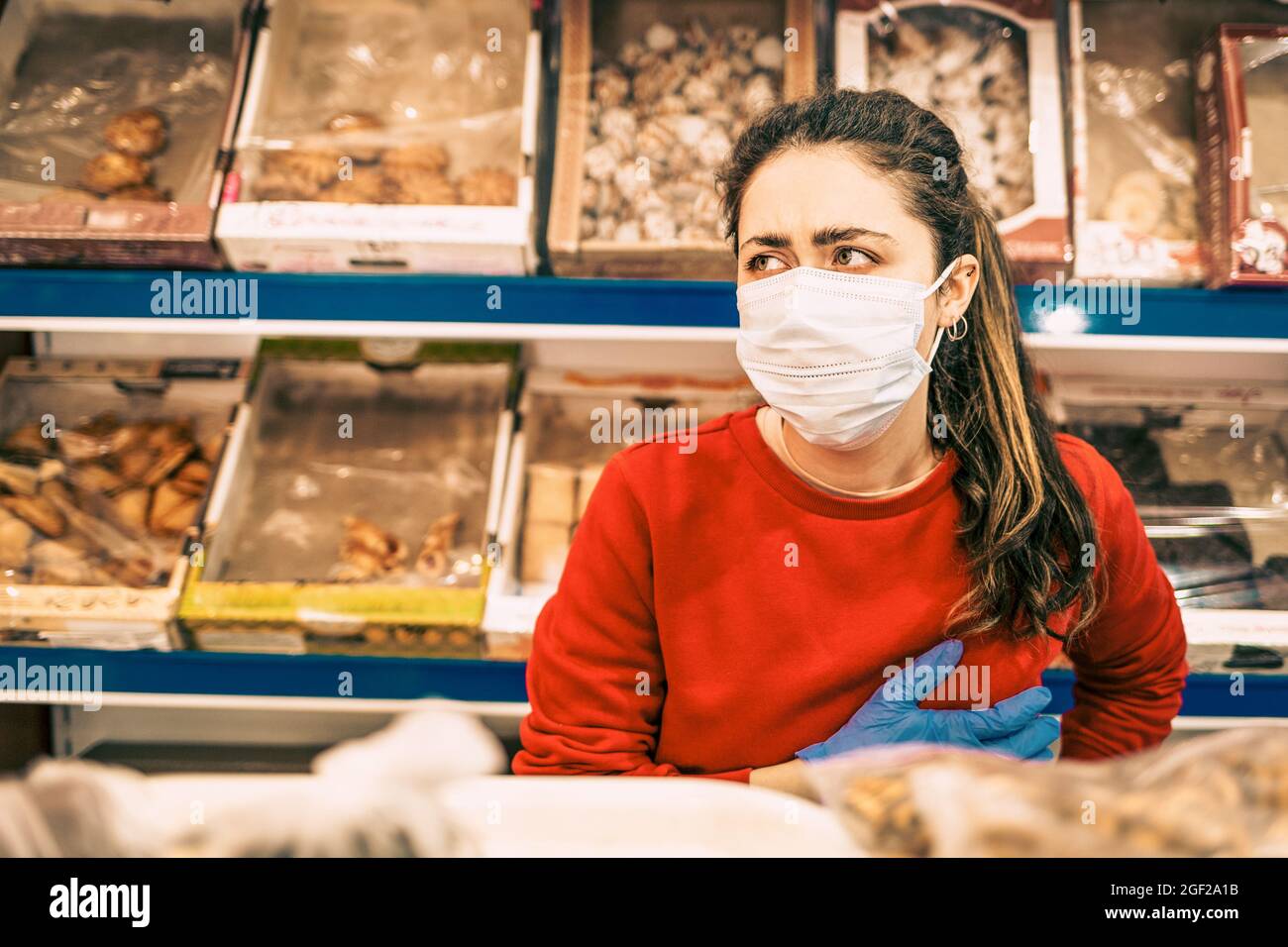 Symptoms of infection. A woman in rubber gloves and a medical mask on ...
