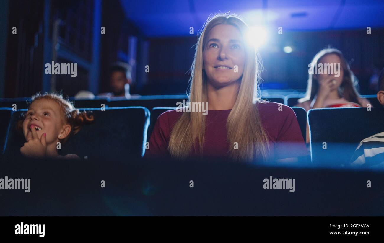 Front view of cheerful young woman in the cinema, watching film Stock ...