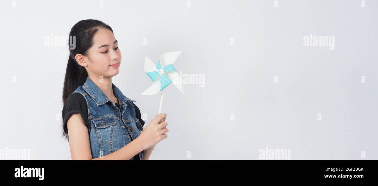 Teenage woman and paper windmill toys. Portrait teen with blue color ...