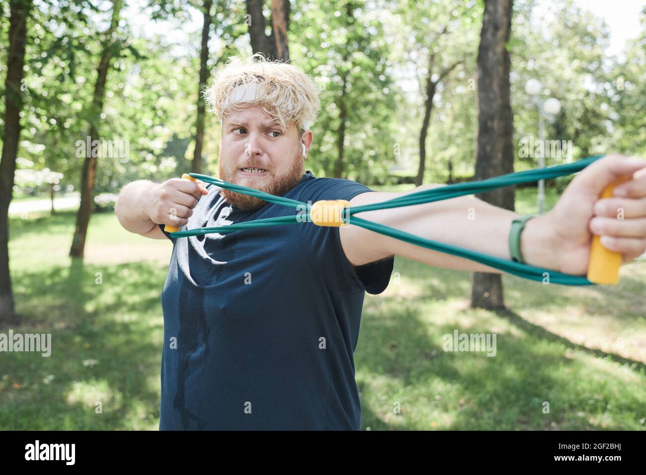 Overweight man exercising with sports equipment and doing stretching ...