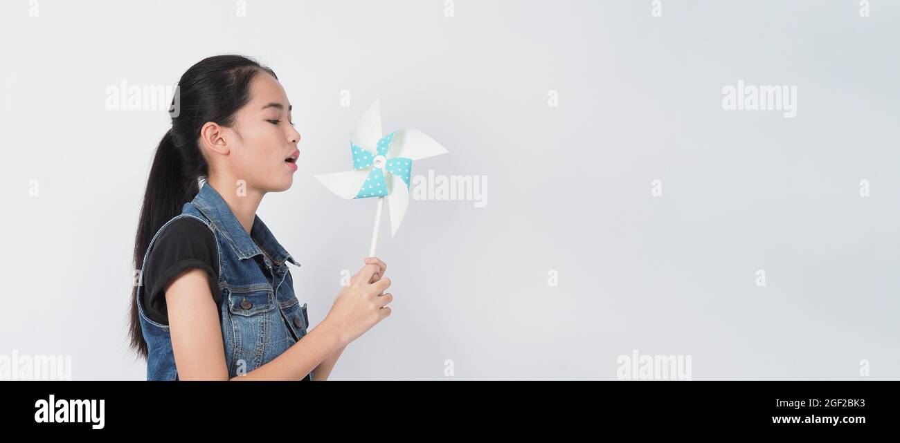 Teenage woman and paper windmill toys. Portrait teen with blue color ...
