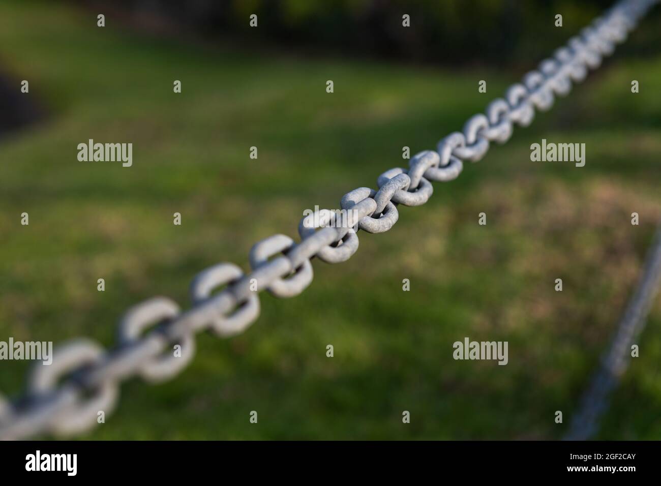 Metal chain hanging in the air outdoor. Selective focus with blurred ...