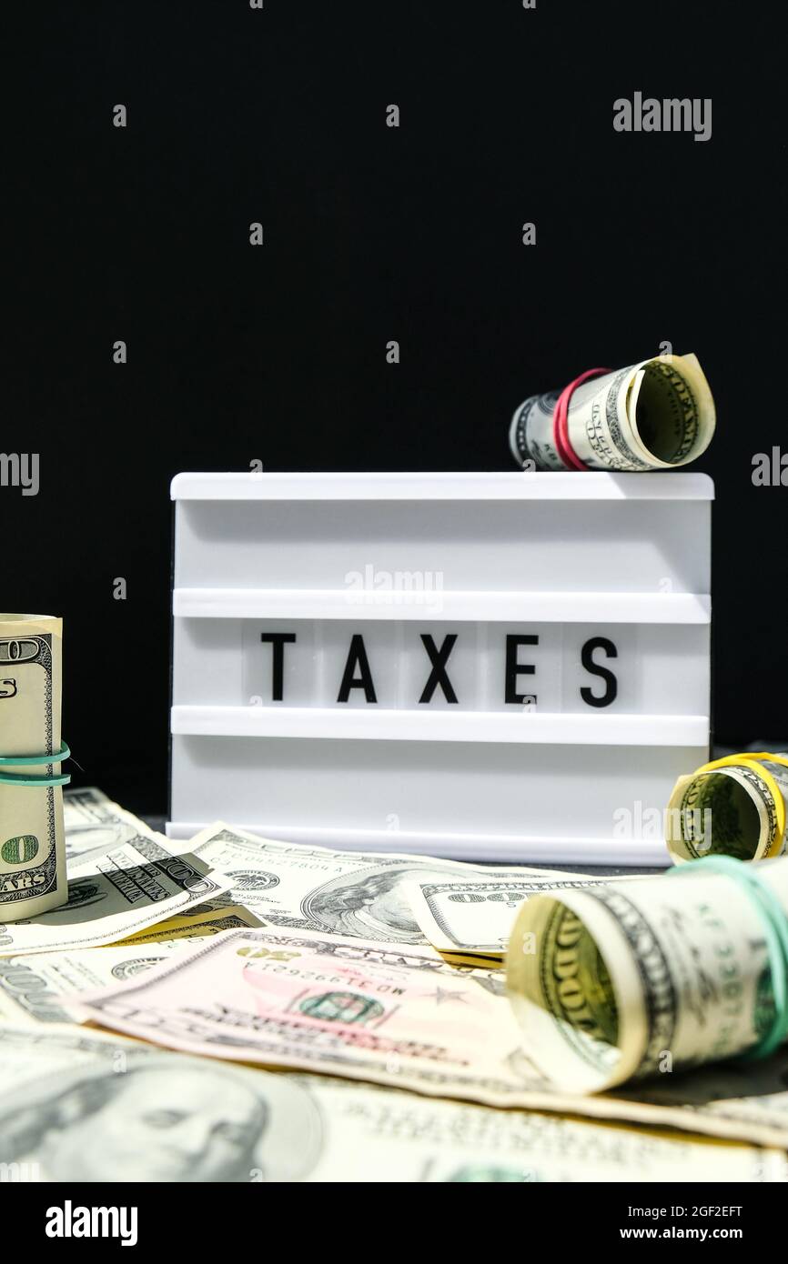 Lightbox board with word TAXES in black letters around Us dollars ...