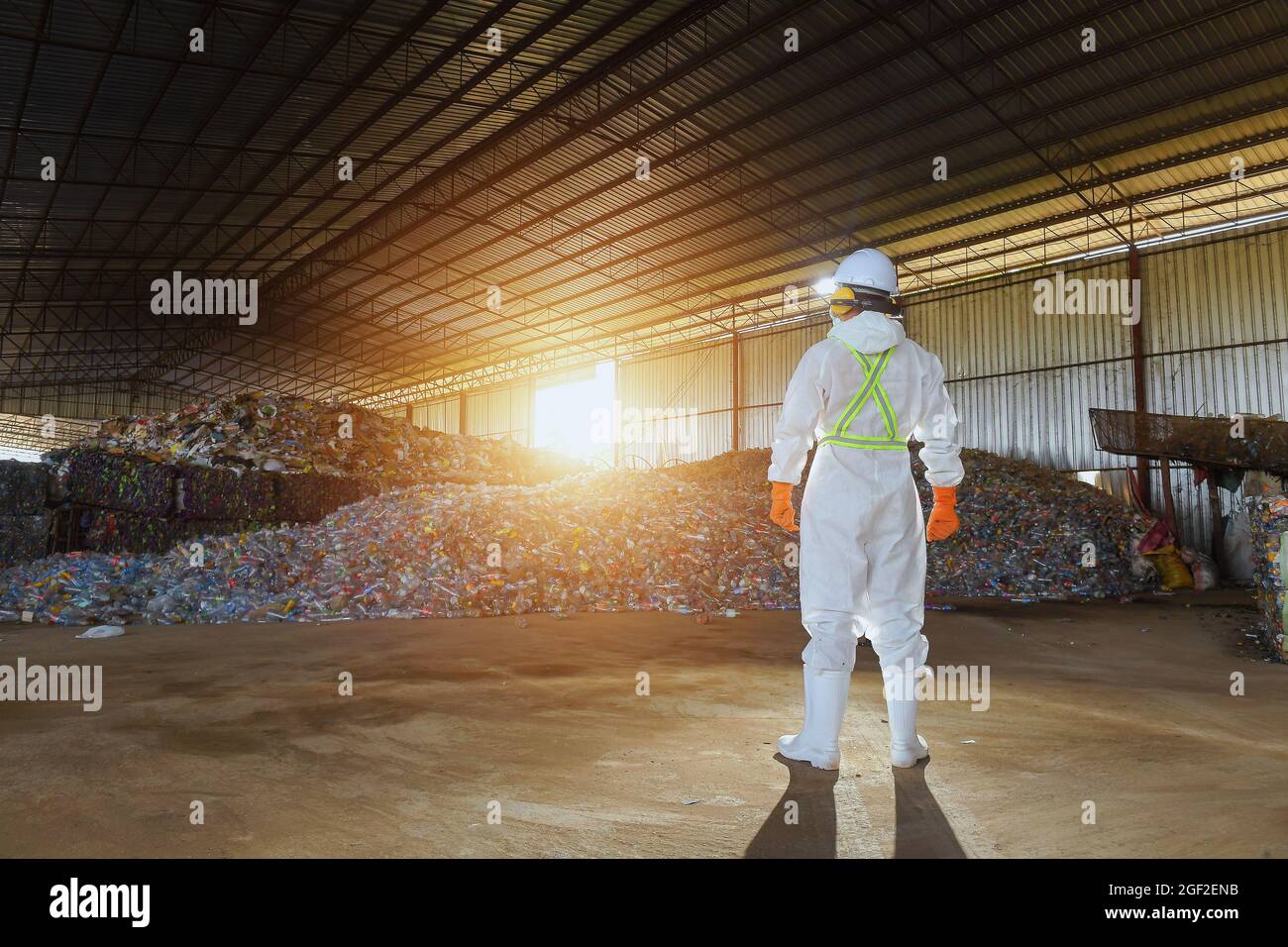 Portrait workers wearing biohazard suits and hardhats working at waste ...