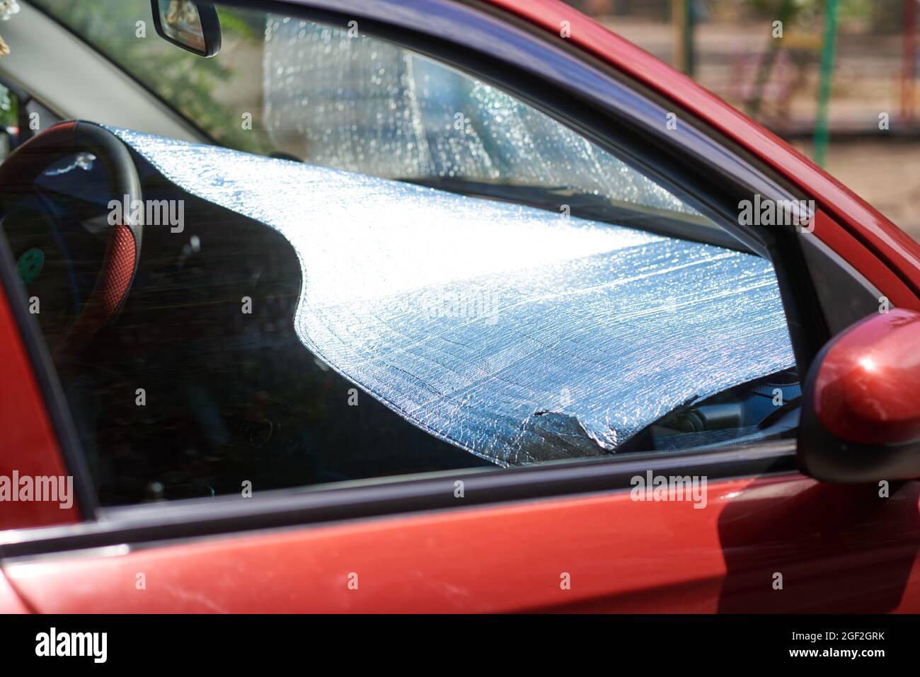 Foil sunscreen shields red car dashboard from sun Stock Photo - Alamy