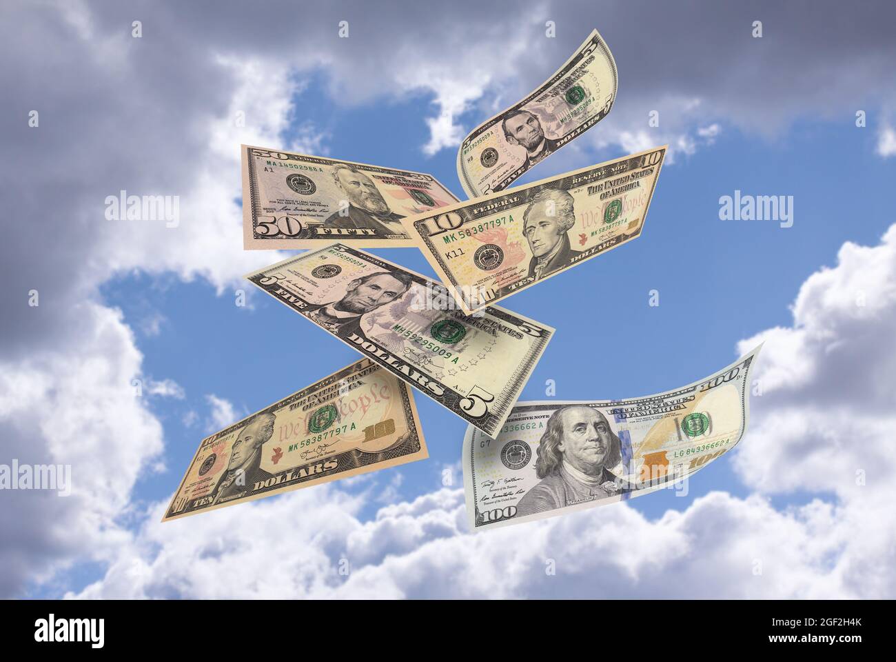 American dollar notes of different value flying with blue sky and white ...