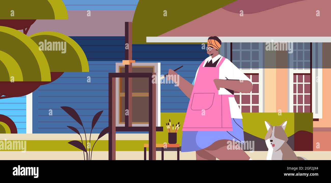 senior african american woman artist with dog painting picture on ...