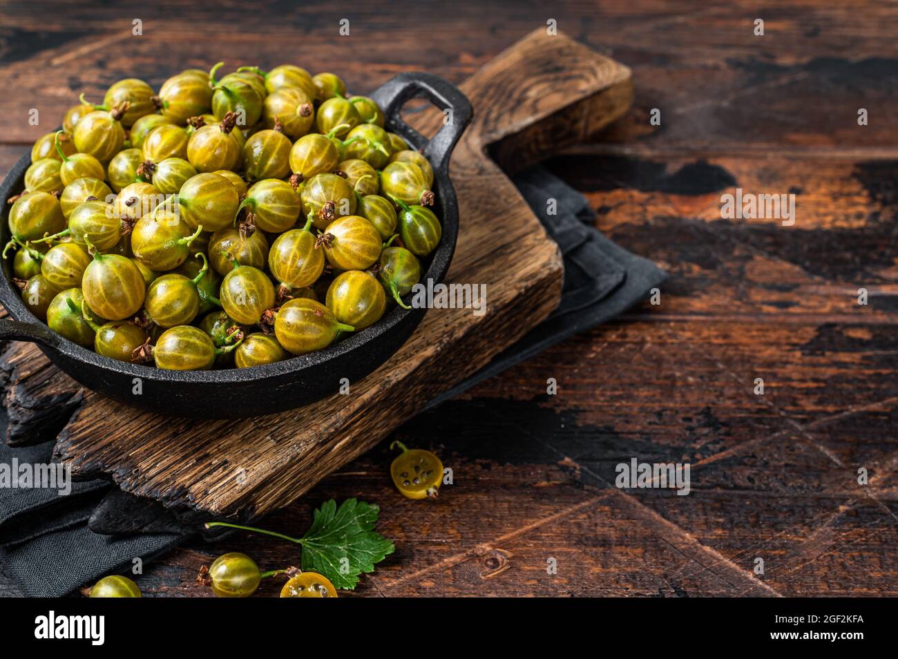 Ripe Green gooseberries ready for cooking jam. Dark Wooden background ...