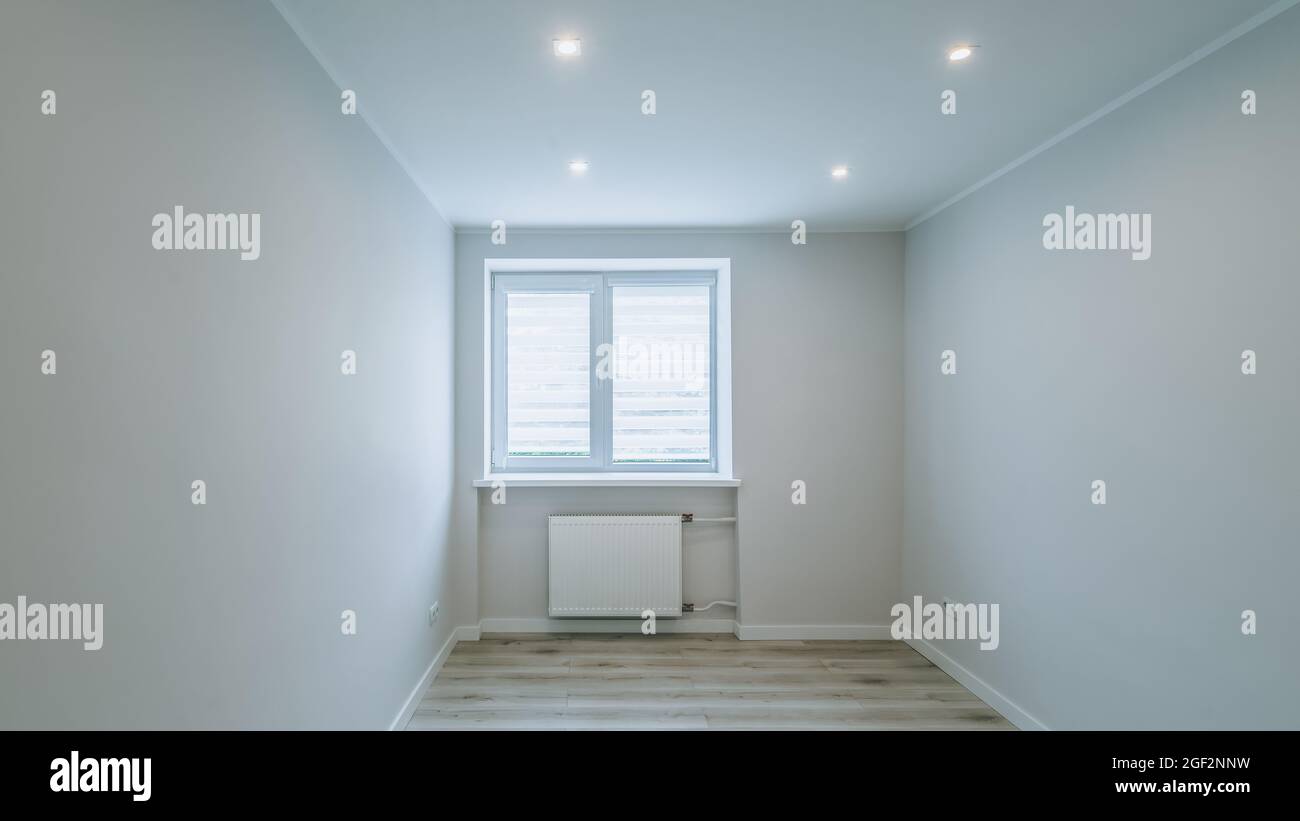 Modern light interior of empty renovated room with white walls. Heating ...