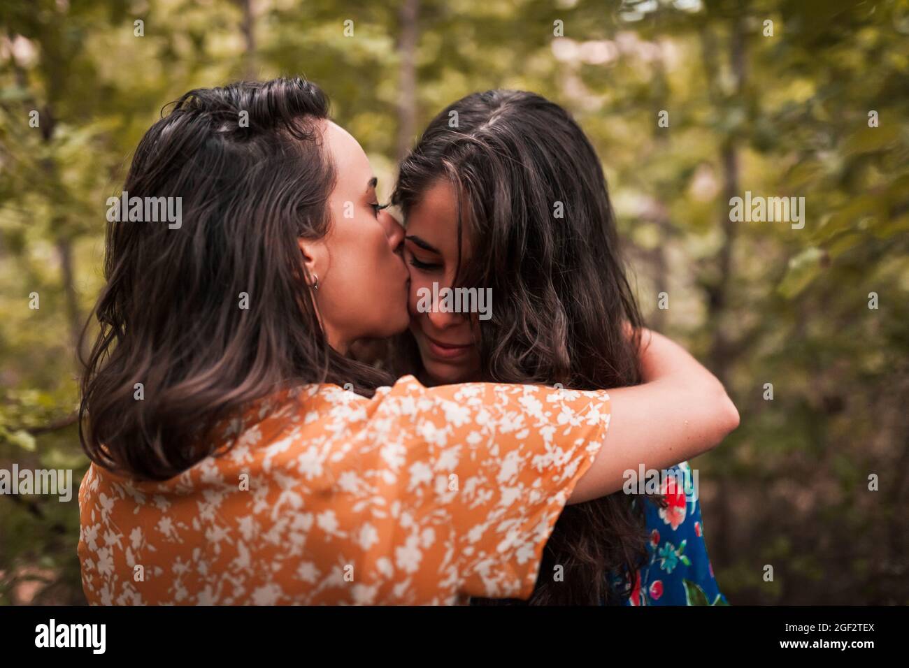 Two young lesbians kissing and caressing each other in the woods Stock Photo - Alamy