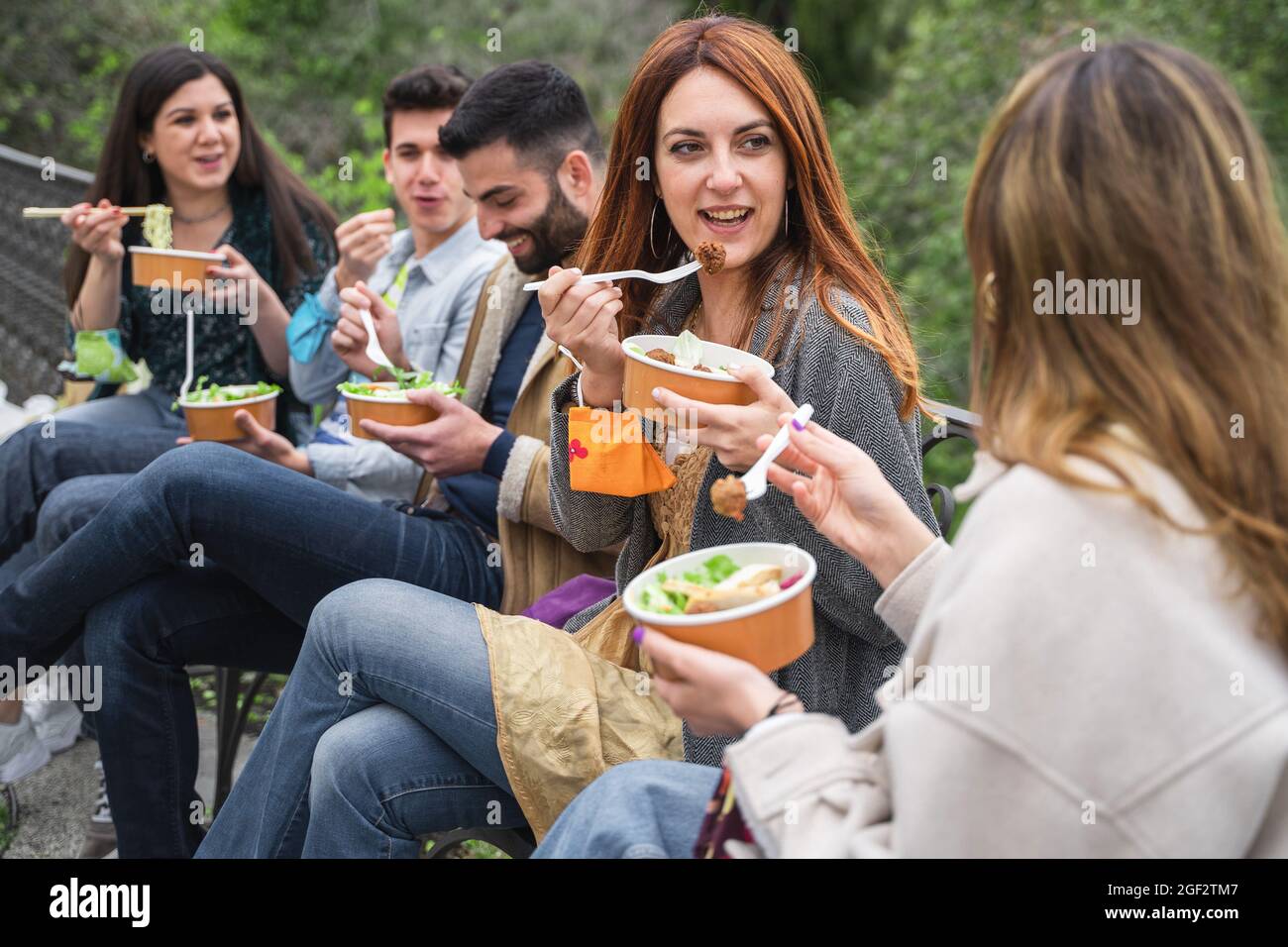 young people gathering at the park. Reunion of best friends eating ...
