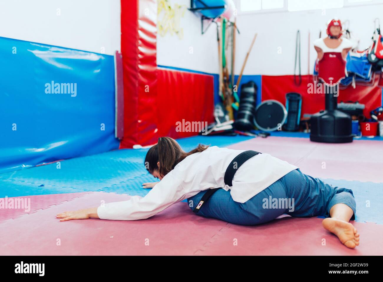Young woman stretching in a dojo wearing taekwondo dobok Stock Photo ...