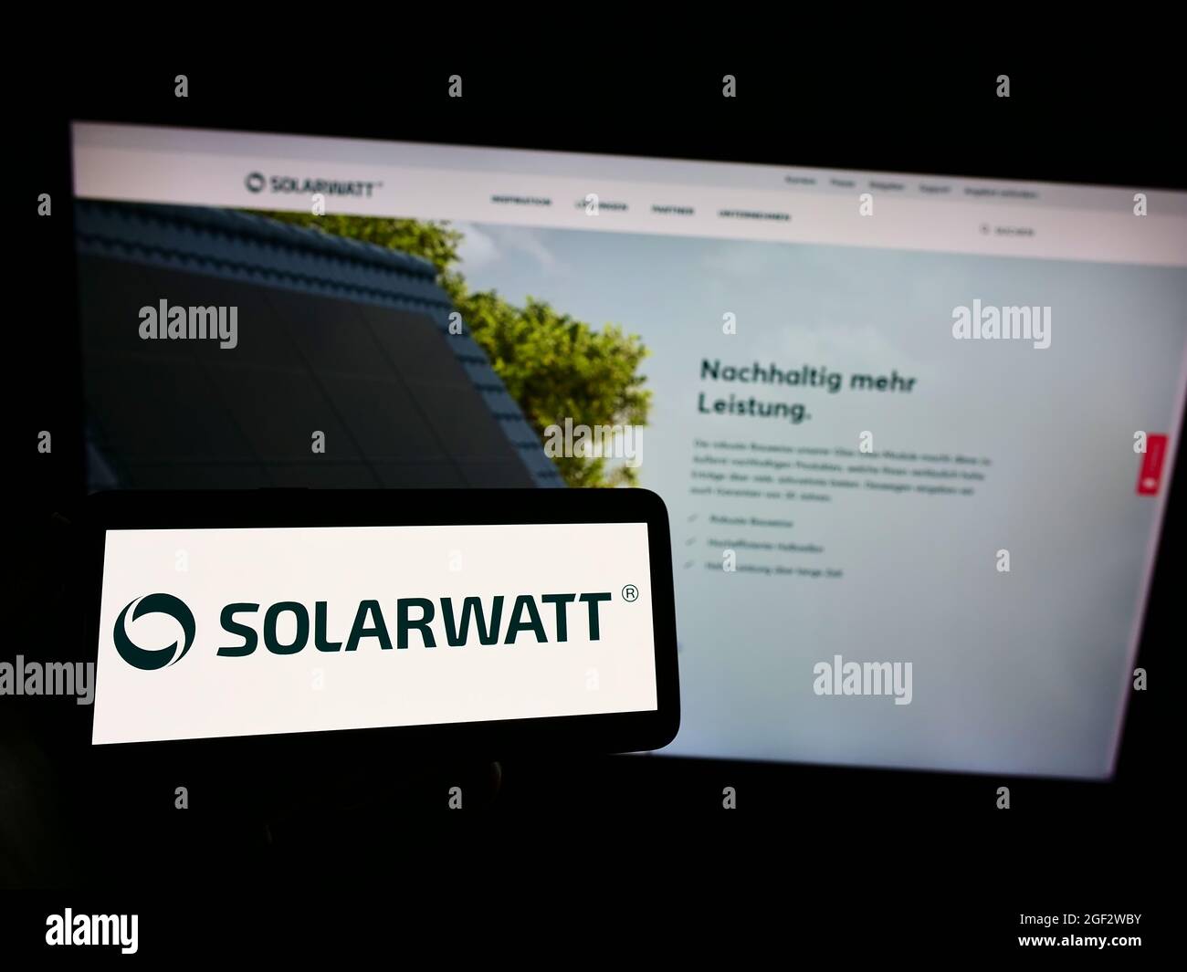 Person holding smartphone with logo of German solar energy company ...
