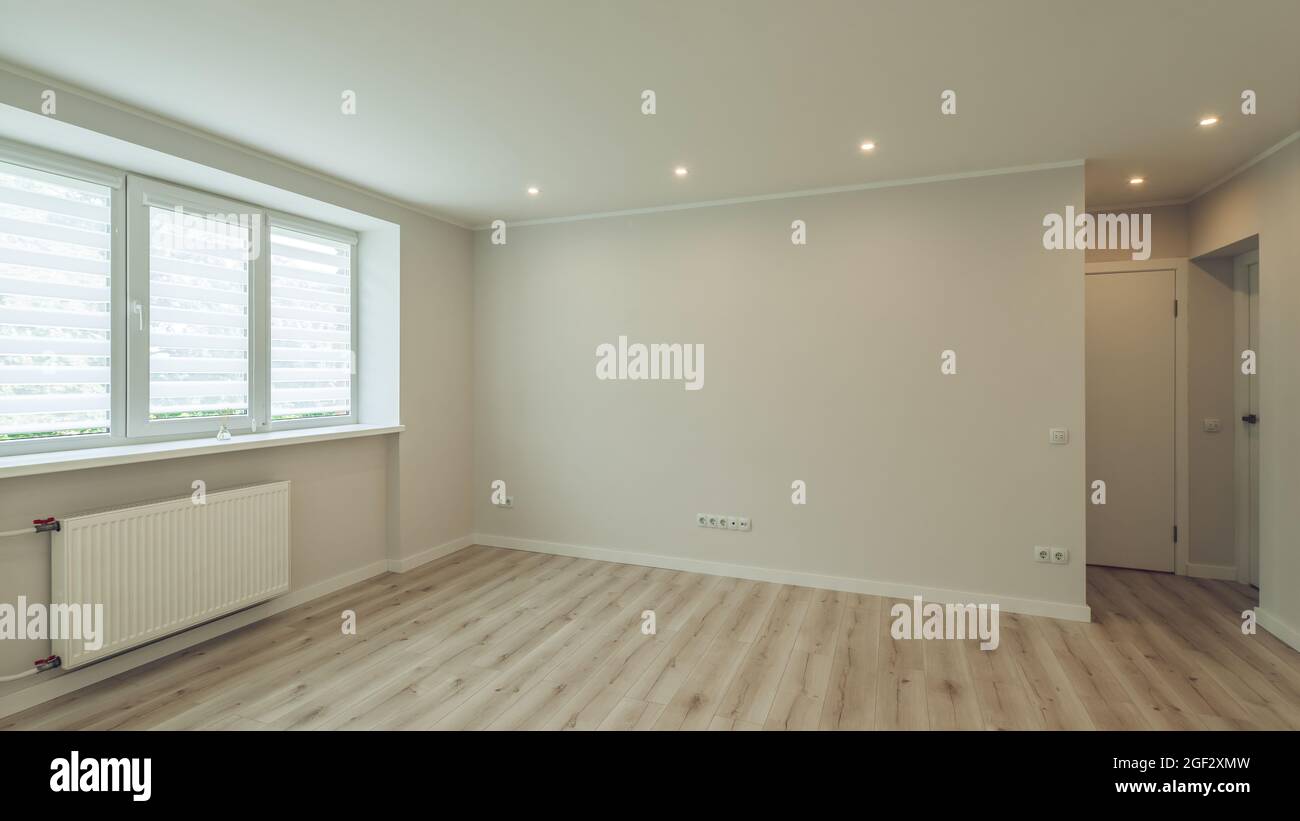 Modern light interior of empty renovated room with white walls. Heating ...