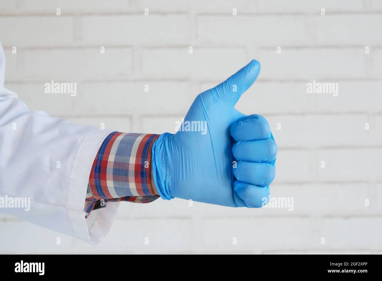 hand in medical gloves showing a thumb-up Stock Photo - Alamy