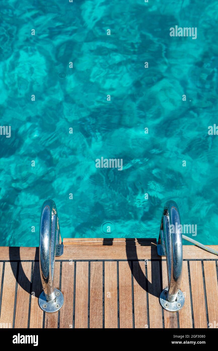 Wooden platform with metal ladder for dives in transparent Aegean calm ...