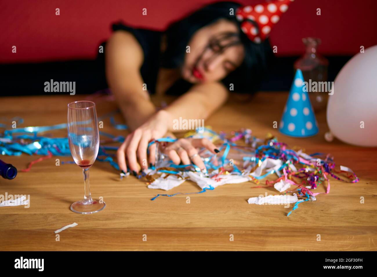 Close up of hand woman hold a glass of champagne, sleeping at table in ...