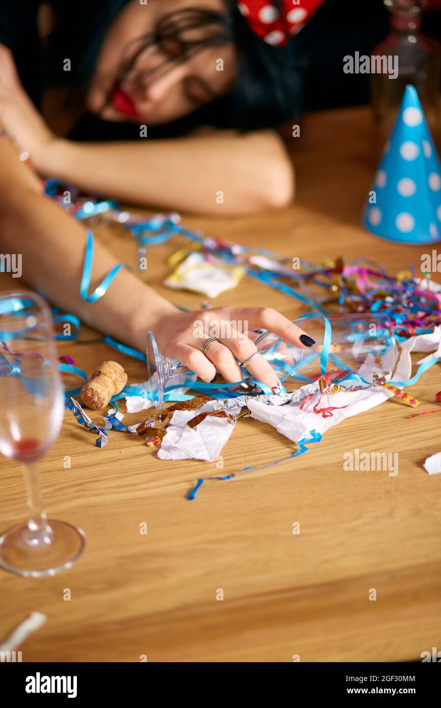 Close up of hand woman hold a glass of champagne, sleeping at table in ...