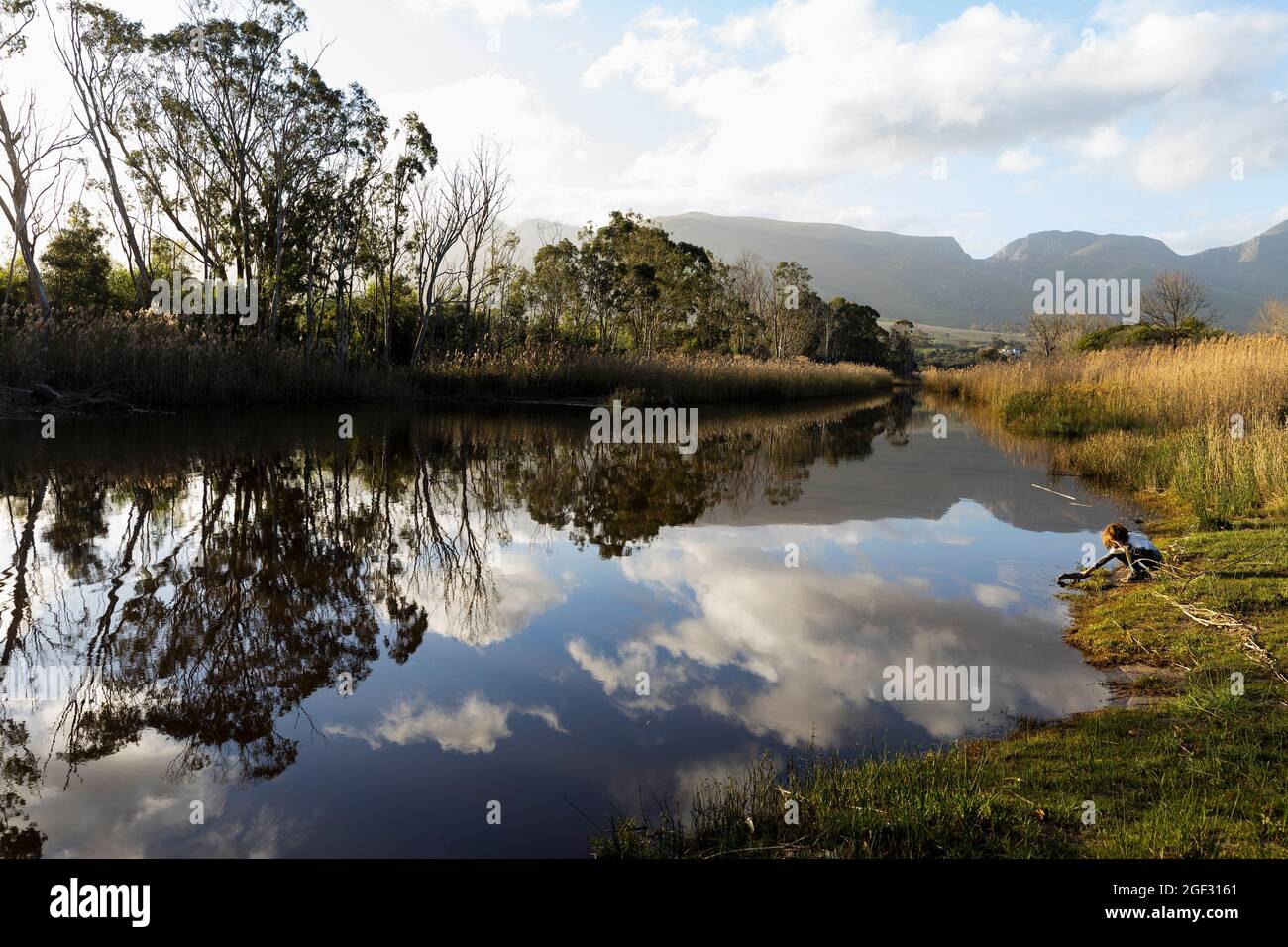 Young boy playing on a river bank Stock Photo - Alamy