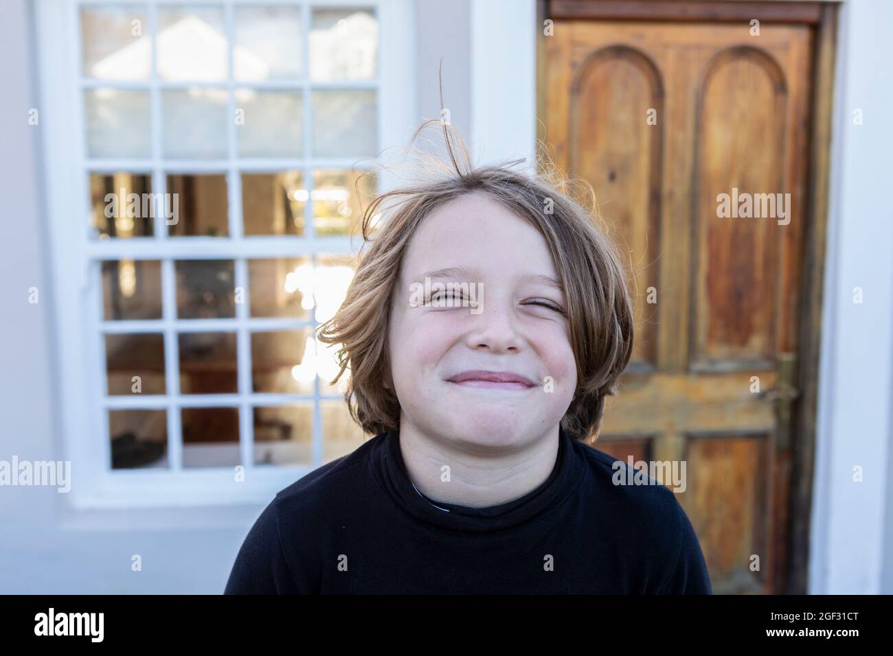 Portrait of young boy posing outside his home, smiling Stock Photo - Alamy