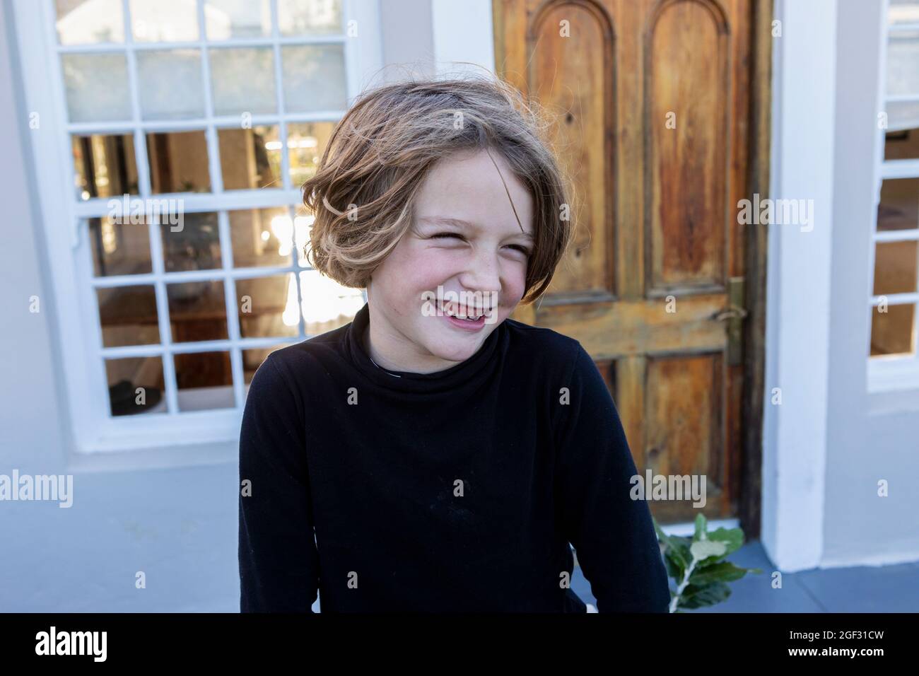 Young boy laughing, looking sideways, head and shoulders Stock Photo ...