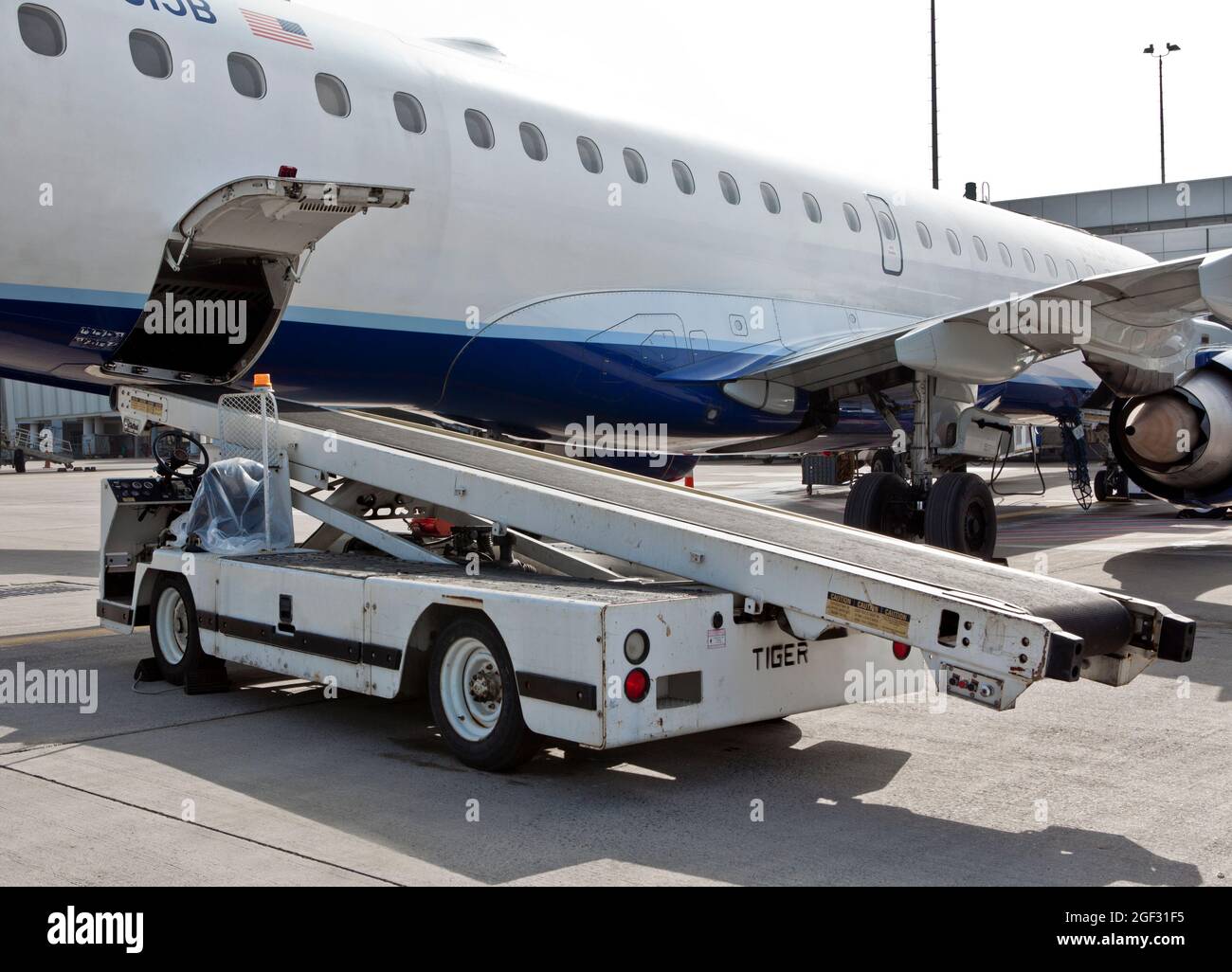 A passenger aircraft on a jetway with a baggage truck vehicle Stock ...