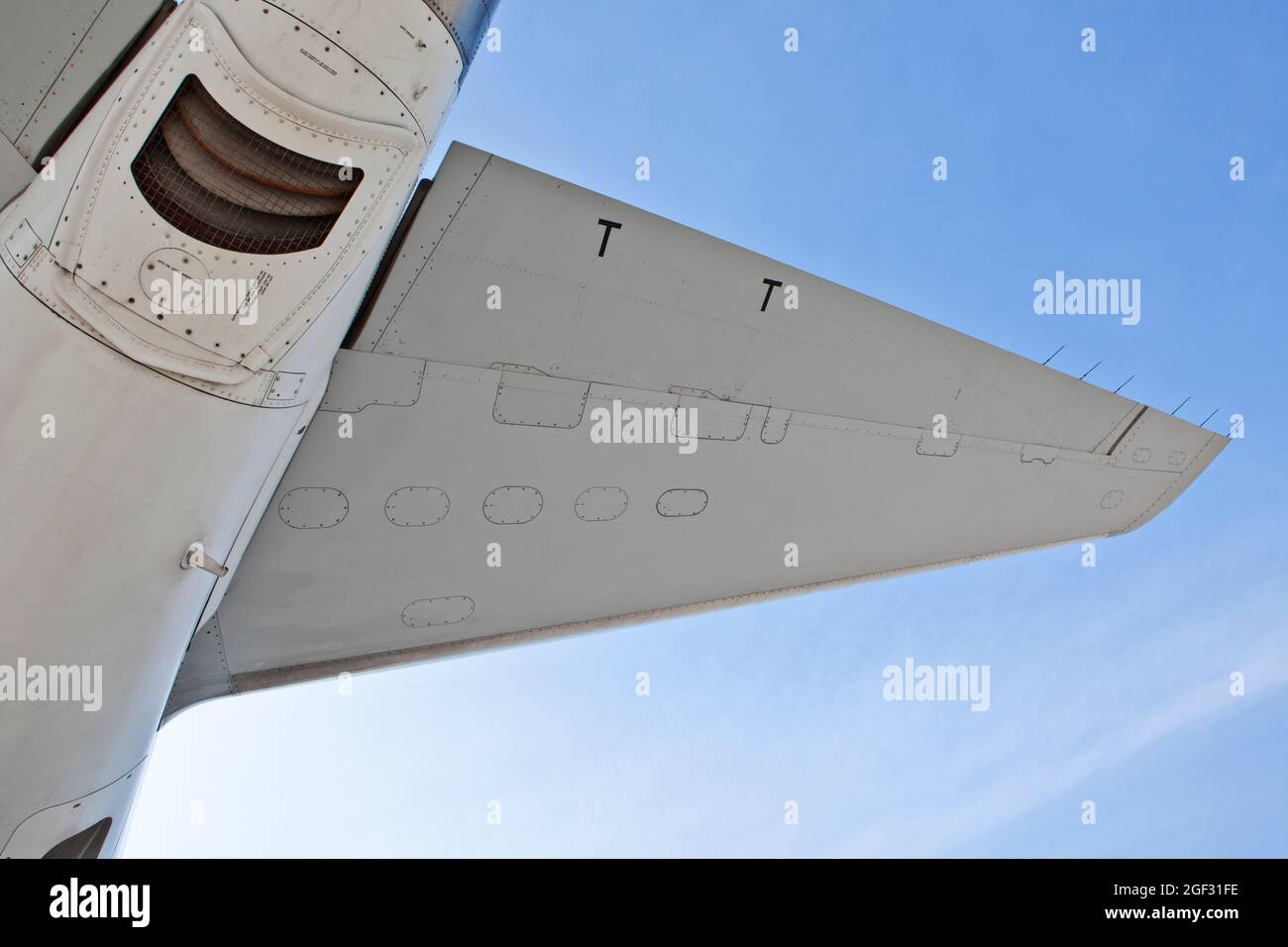 The underside of an aircraft, wings and mesh covered exhaust outlet ...
